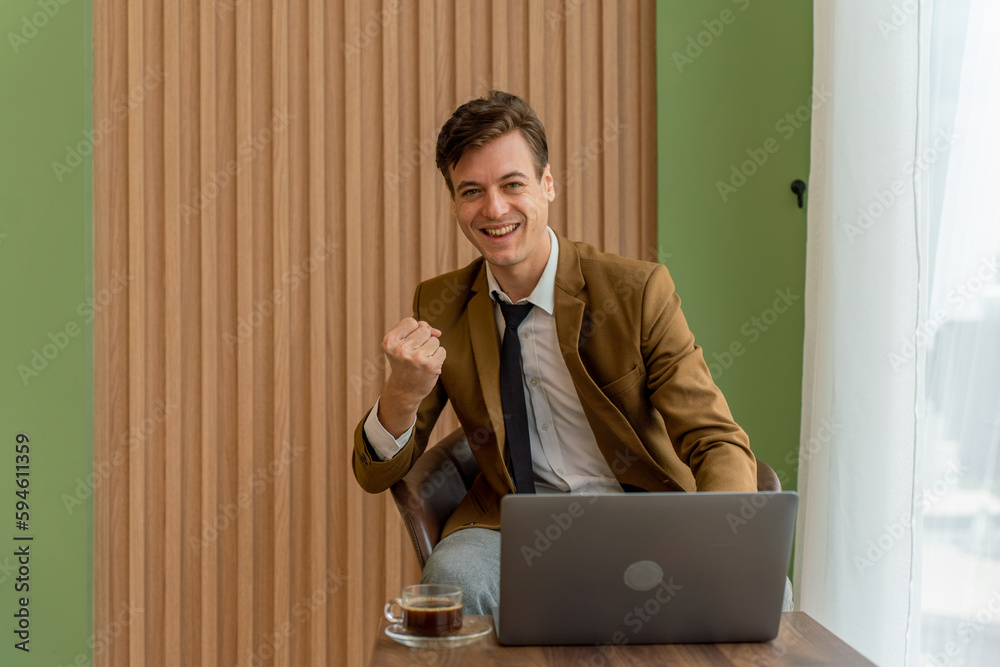 Moment of success. Handsome white businessman using laptop celebrating ...