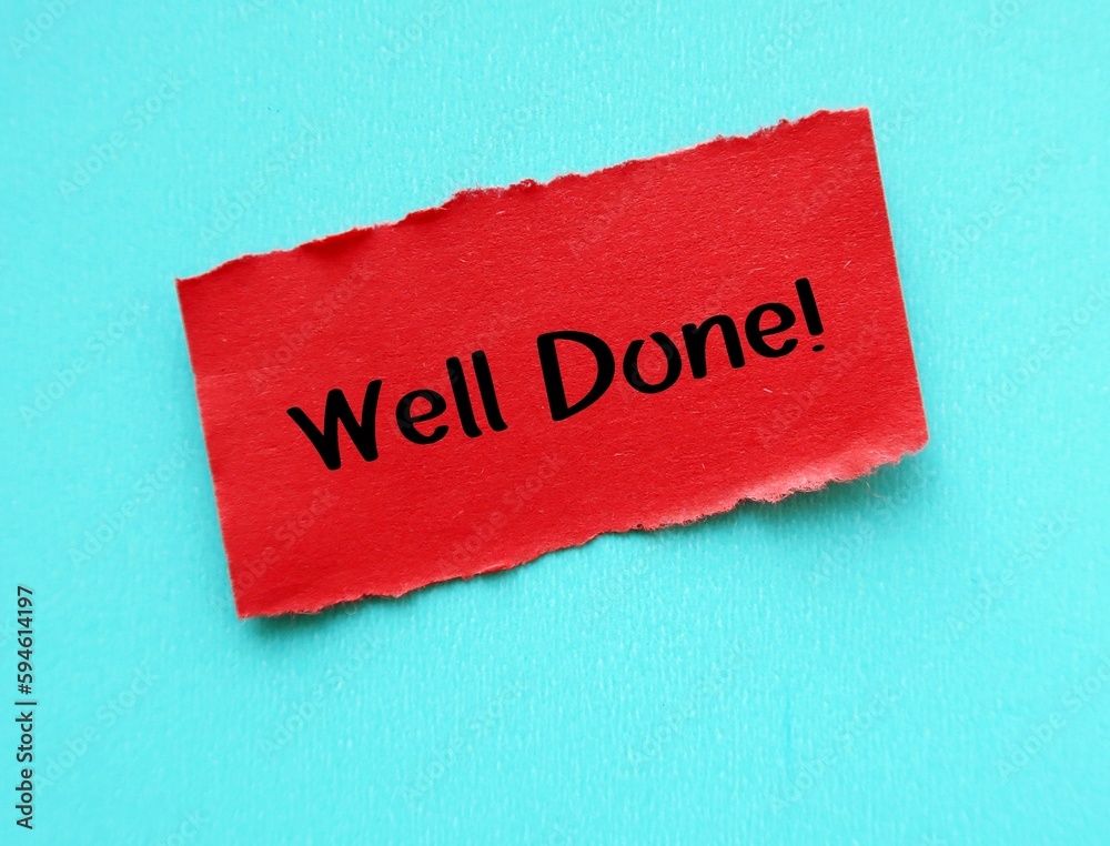 red paper on blue background with handwritten text WELL DONE, concept ...