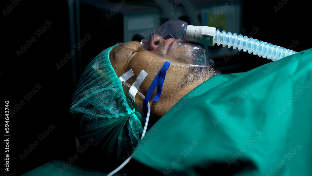 Foto de Close-up face male patient intubated lying on operating table ...