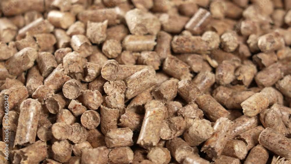 Closeup view 4k video of brown organic wooden pellets. Pellets slowly ...