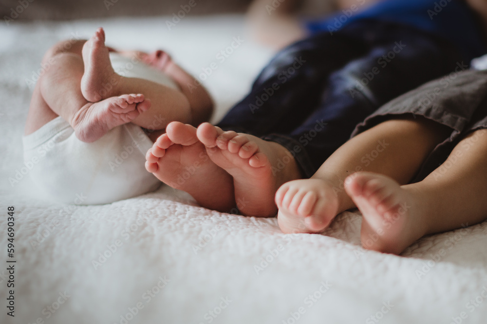 three children's feet on on a bed with a newborn baby Stock Photo ...