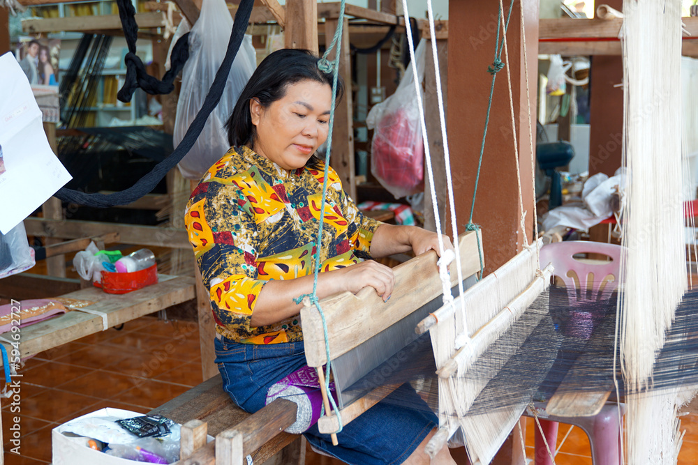 Asian women tourists try weaving with a hand loom in the concept of ...