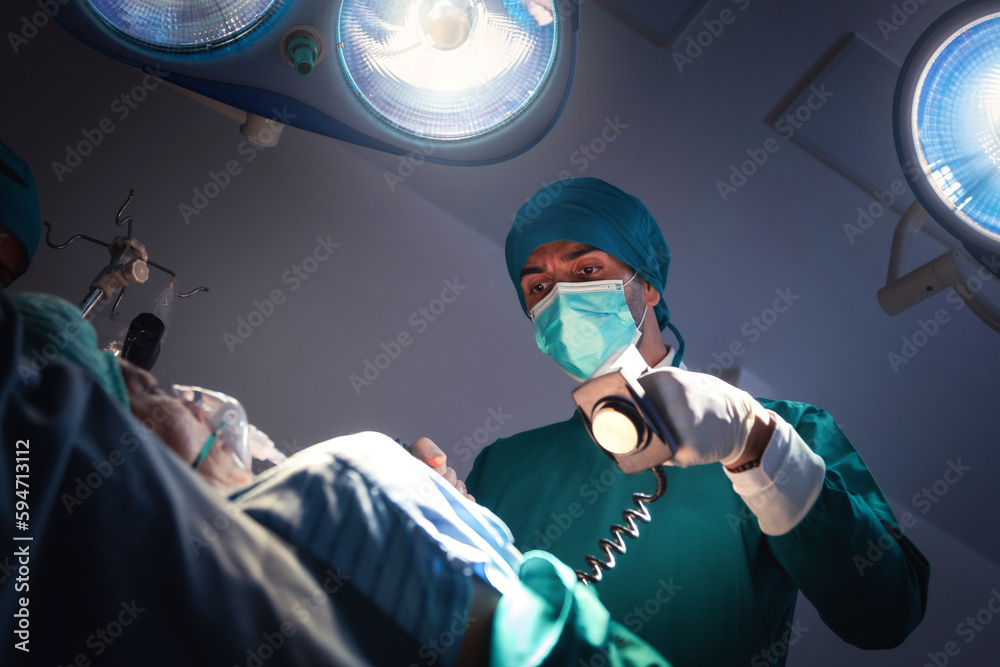 Doctors and team performing using defibrillator to give electrical ...