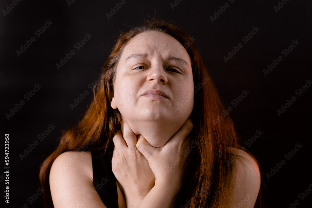 Suffering young woman choking throat. Female portrait isolated on black ...