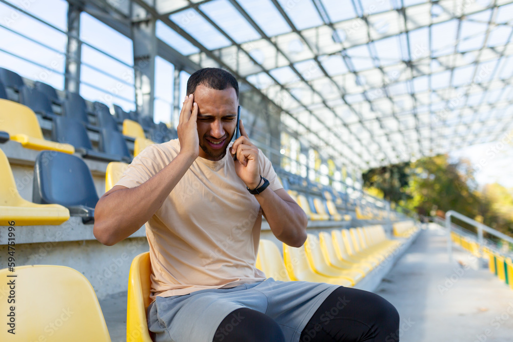 Foto de Head injury in sports. Young hispanic male postman sits in the ...