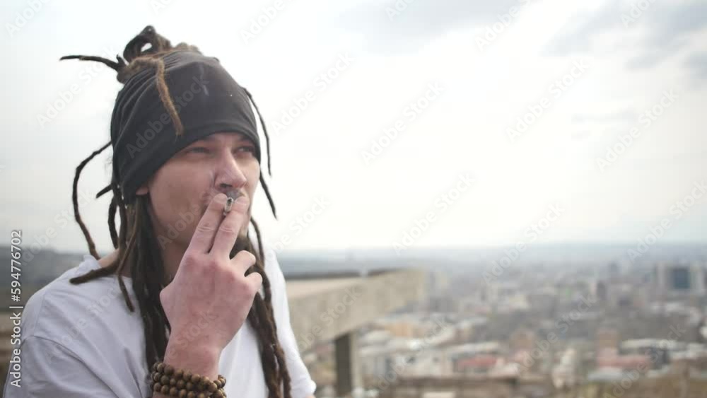 Portrait of one young attractive guy smoking a cigarette with ...