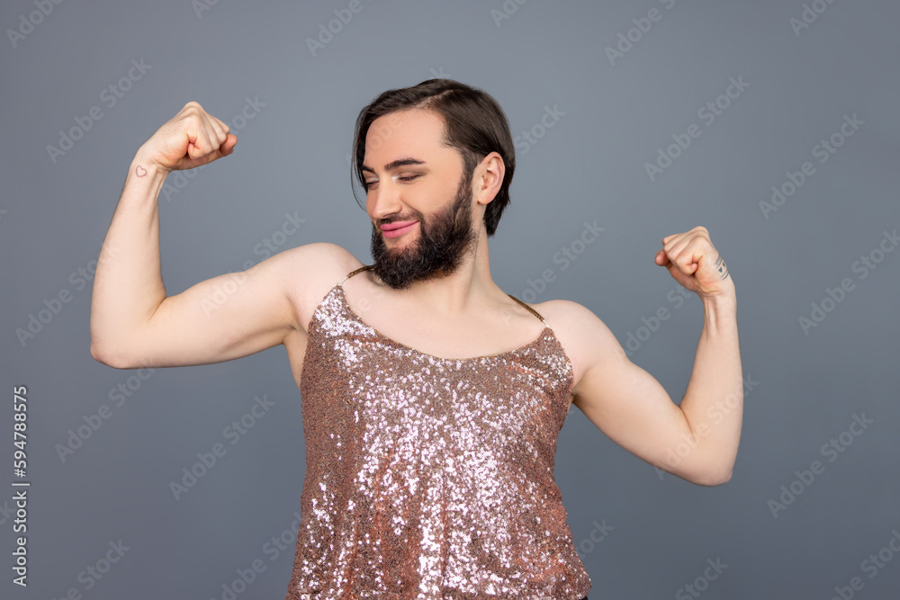 Satisfied proud transsexual person in shiny tank top showing biceps and ...