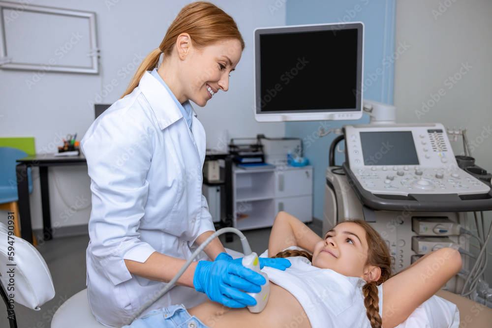 Doctor performing ultrasound scan on little girl medical specialist ...