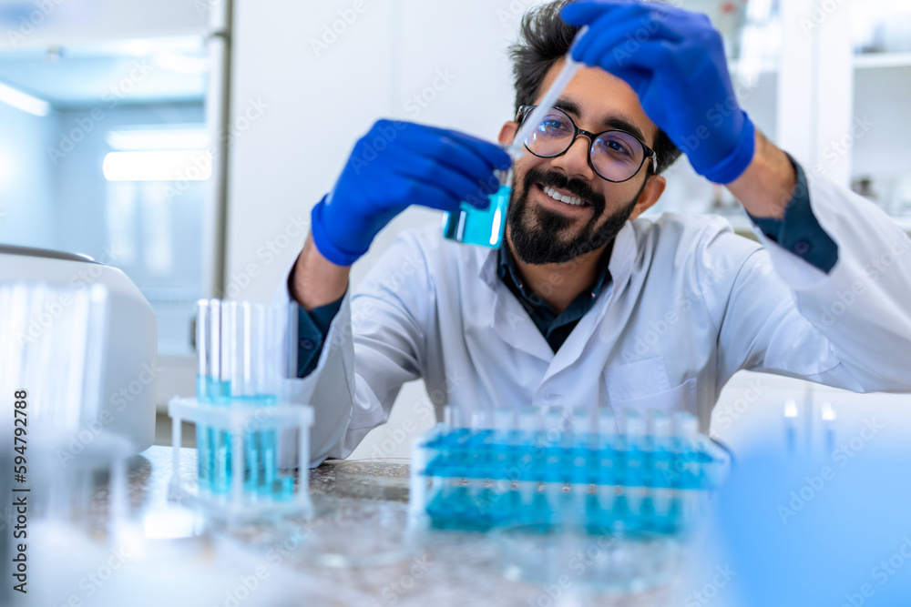 Scientist man testing chemical sample in flask at laboratory with lab ...