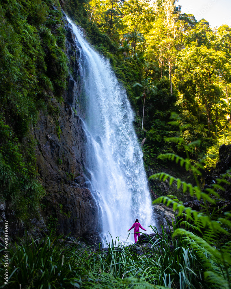 hiker girl standing in front of large tropical waterfall in australian ...