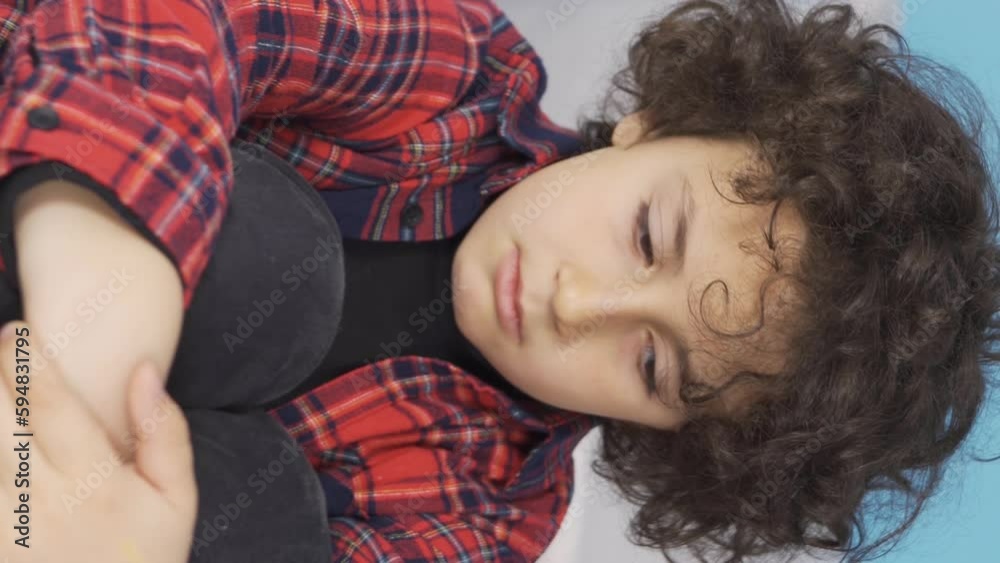 Vertical video of Depressed boy feeling unhappy in his room. The boy ...