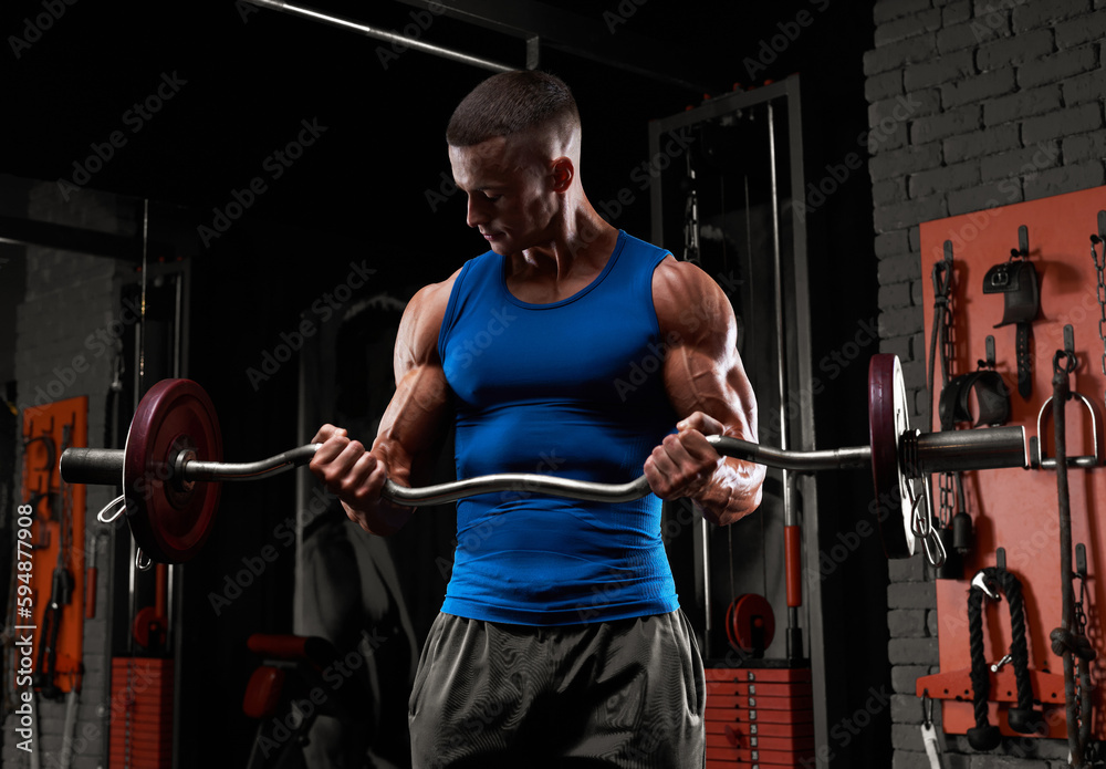 Handsome strong athletic man pumping up muscles, training, bodybuilding ...