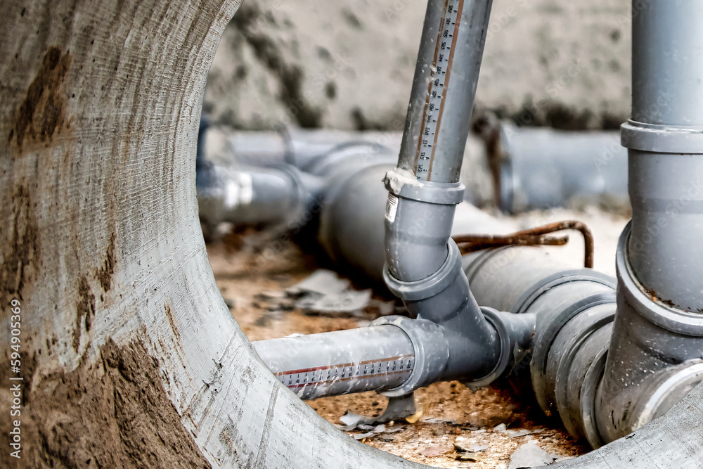 Sewer pipes in home basement. System of gray sanitary pipes when building a house. Sewer ...