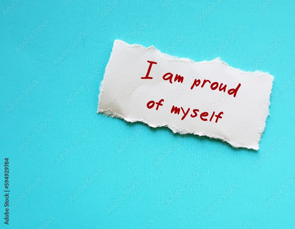 on blue copy space background, torn paper with handwriting I AM PROUD OF MYSELF, positive mantra ...