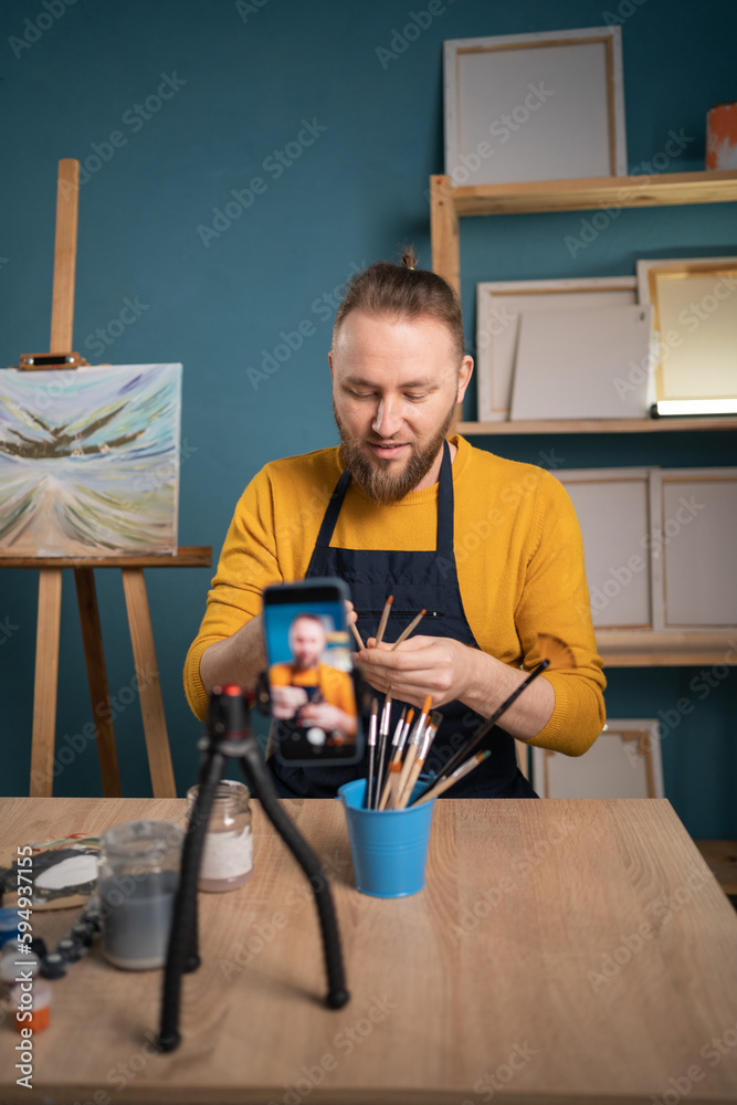 Creative man vlogging his painting technique and skill in art studio ...