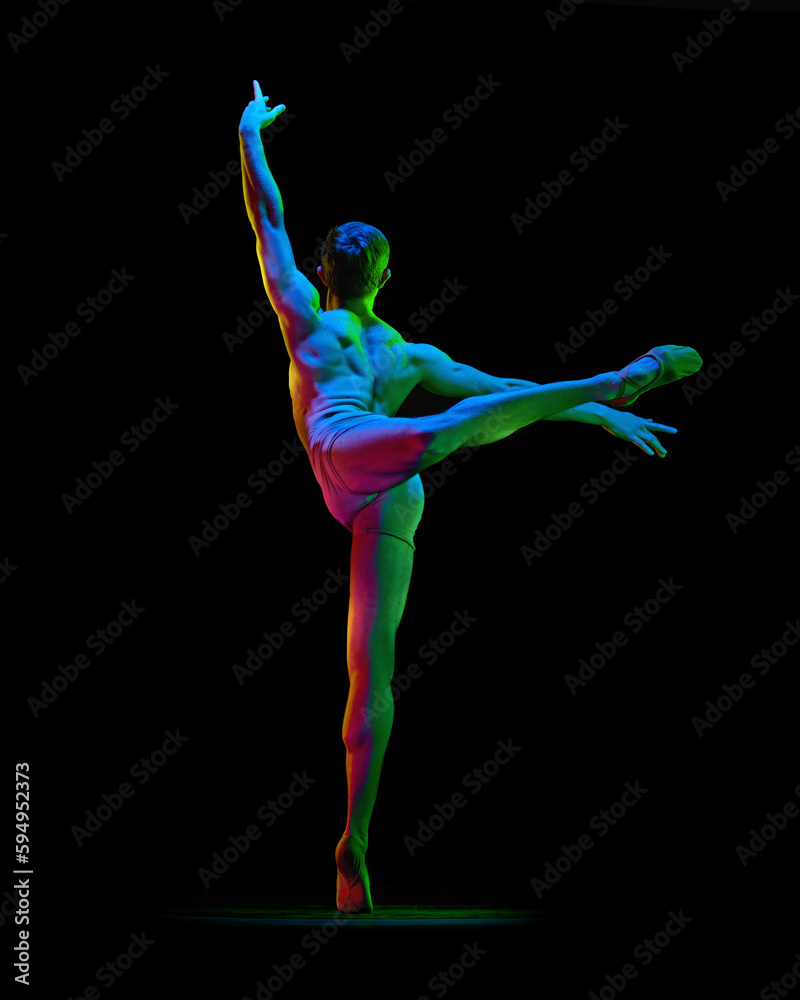 Portrait of handsome muscled male ballet dancer dancing over dark ...