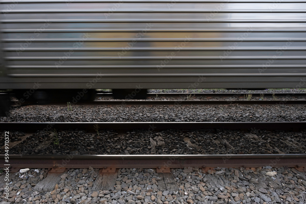 Side view of a train (motion blur) passing a platform at a station ...