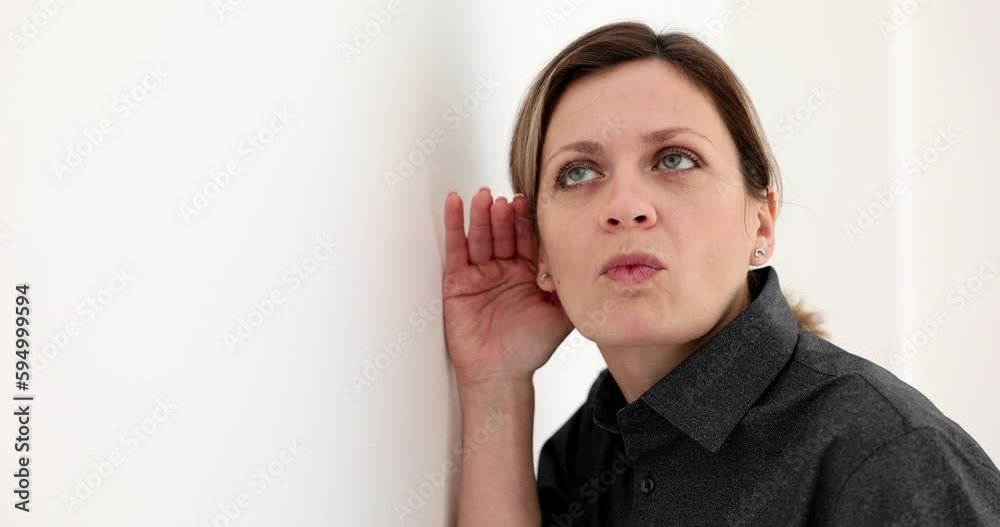 A business woman is eavesdropping through a wall, a close-up ...