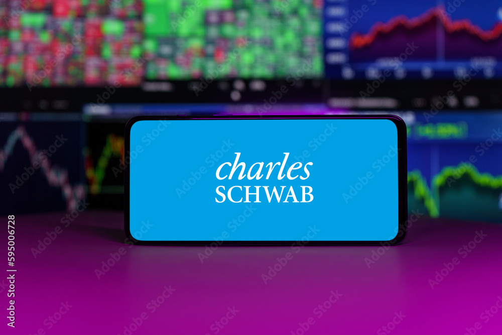 Charles Schwab stock market index in front of stock market charts ...
