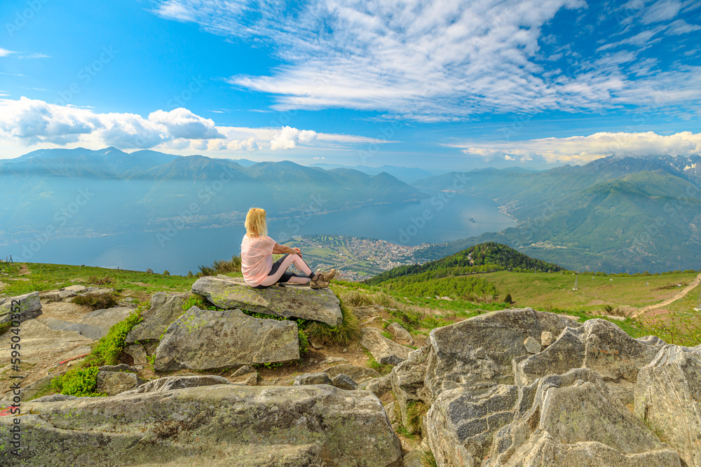 relaxing woman taking a break after trekking, sitting on top of Cardada ...
