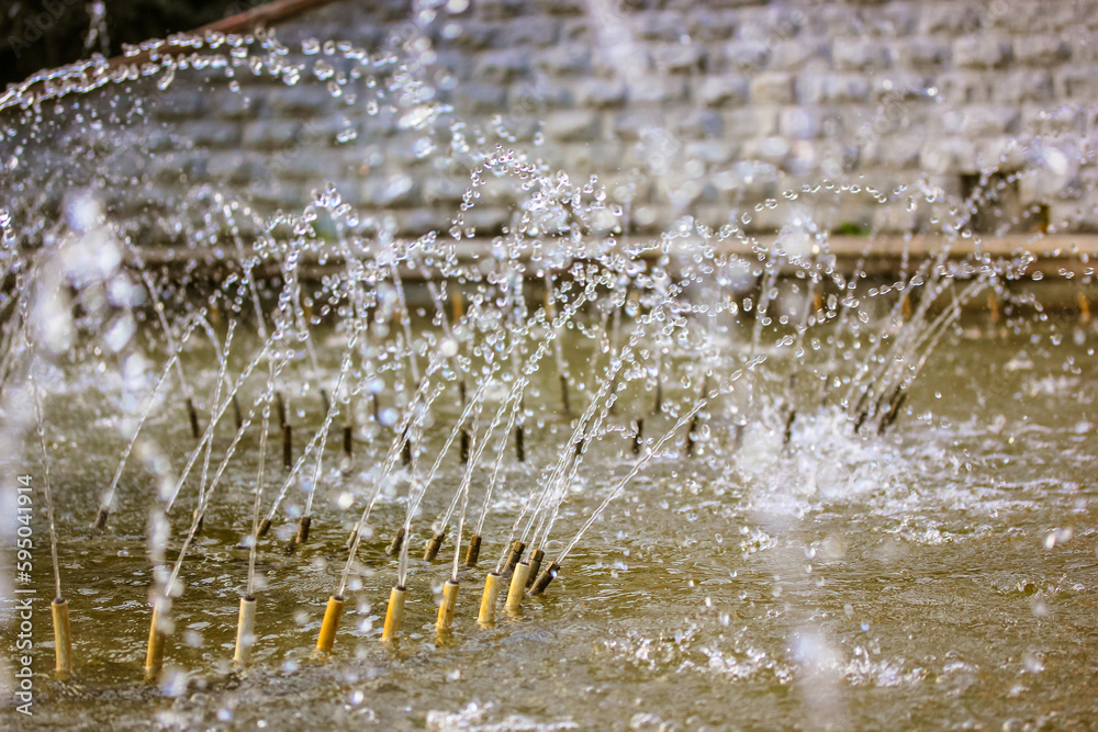 Splashing water in the fountain at summer city public urban park. Water ...