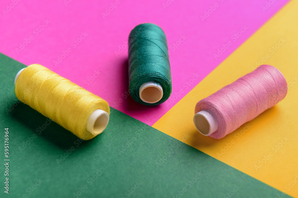 Set of thread spools on color background Stock Photo | Adobe Stock