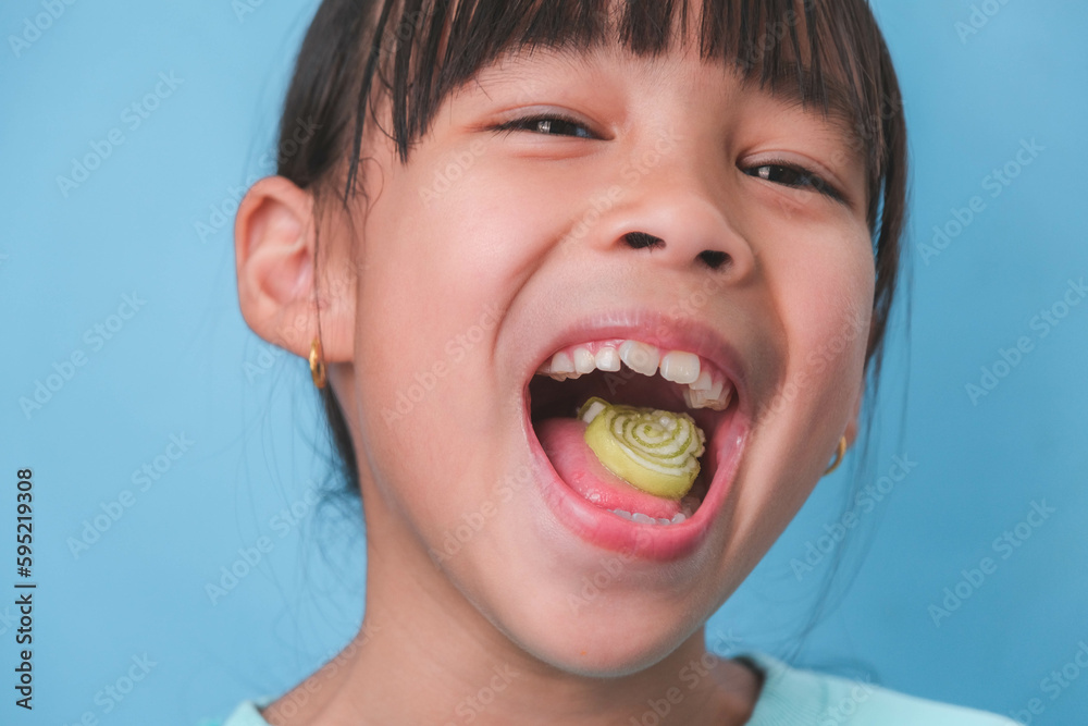 Smiling cute little girl eating sweet gelatin with sugar added isolated ...