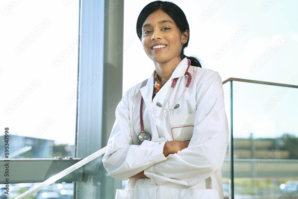 Portrait of smiling medical student with arms crossed looking at camera ...