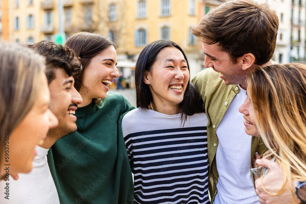Multiracial young group of happy millennial people laughing together in city street. Diverse ...