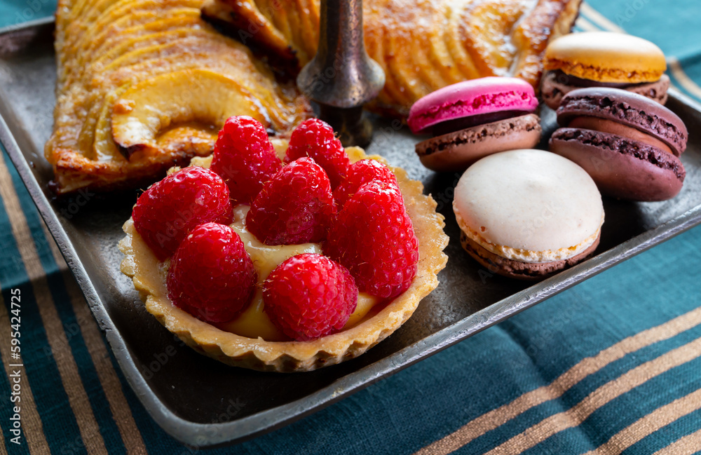 High tea with sweet baked tart with ripe red raspberry, apple cake with ...