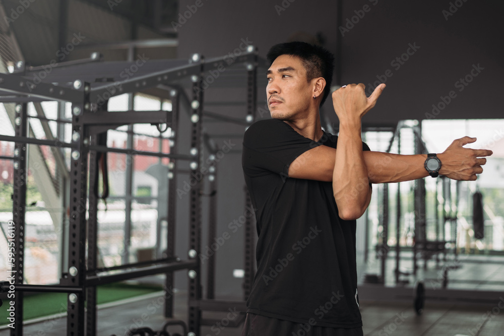 Strong asian man streching body before exercise at crossfit gym ...