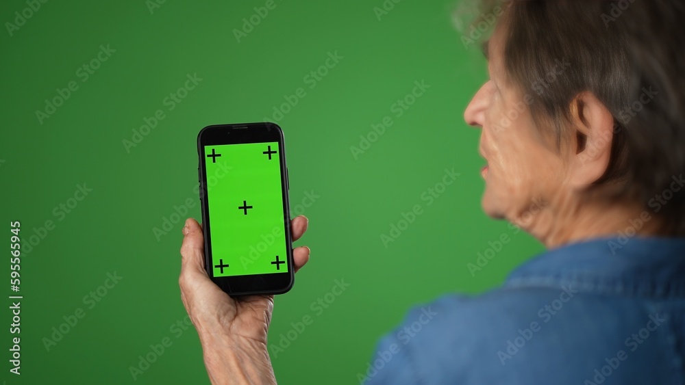 Over the shoulder view of elderly woman talking on smart phone with ...
