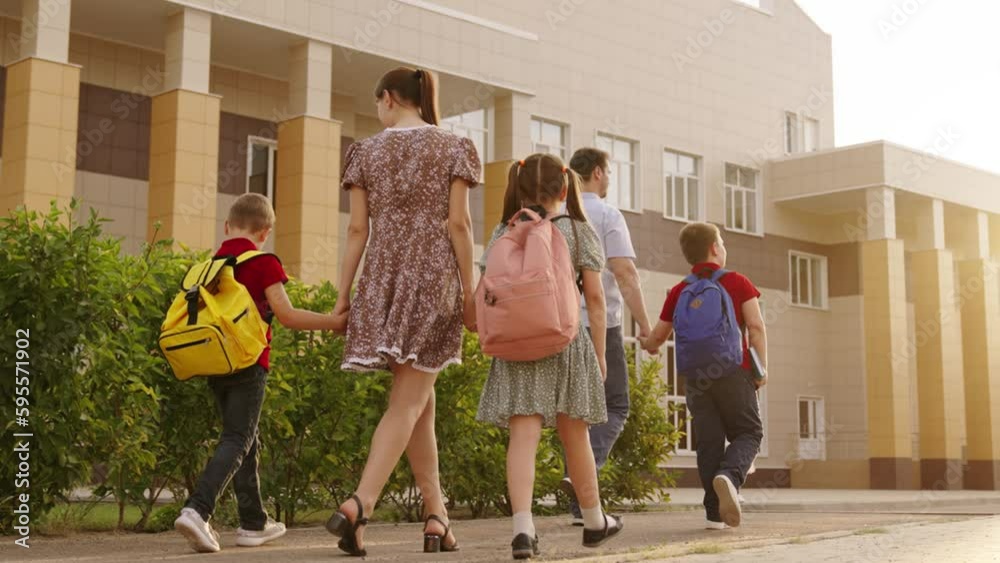 Father mother by hand lead child boy girl with school backpacks backs ...