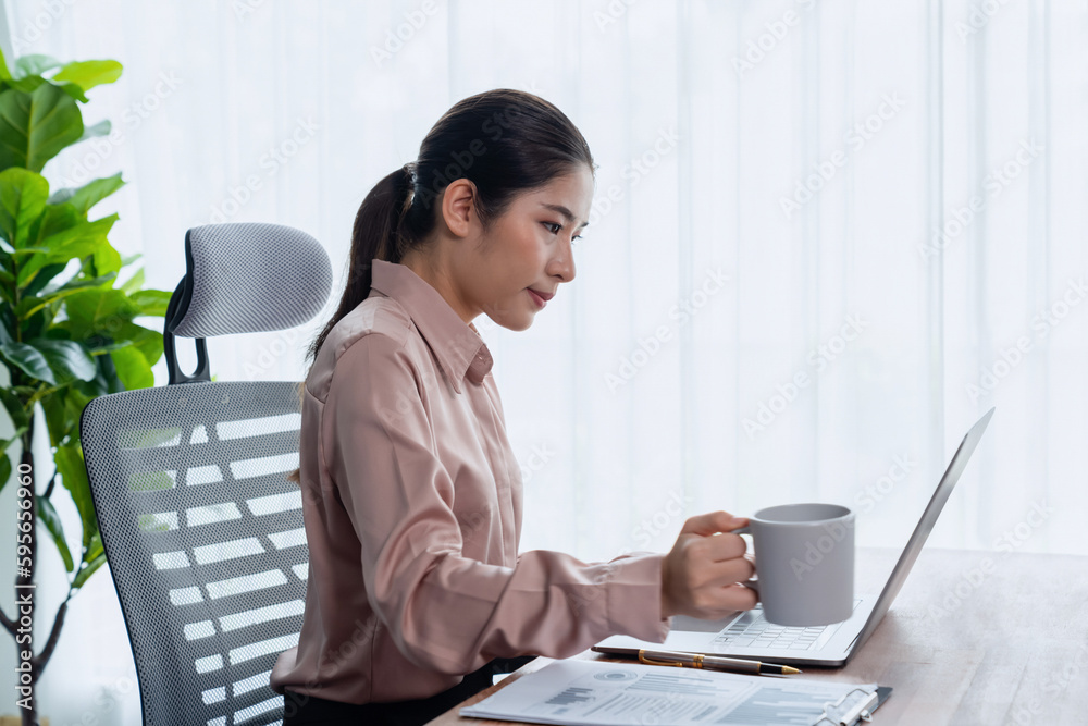 Young asian businesswoman is working and taking notes in her modern ...