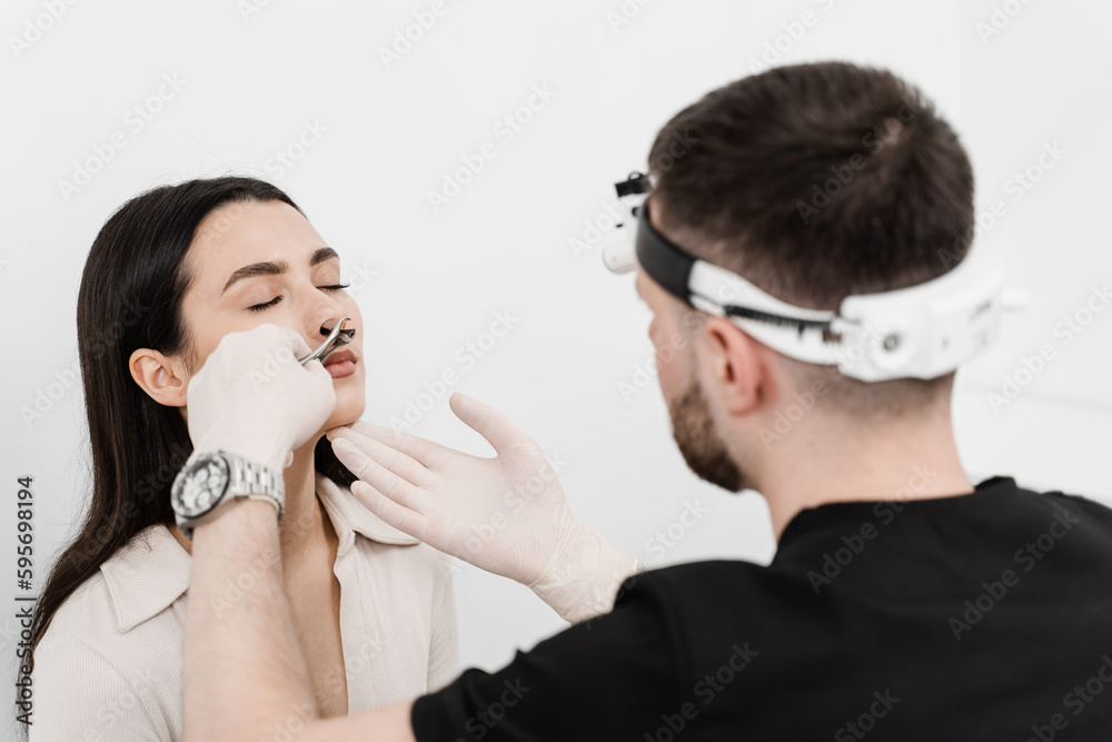 Otolaryngologist examines girl nose before procedure of endoscopy of ...