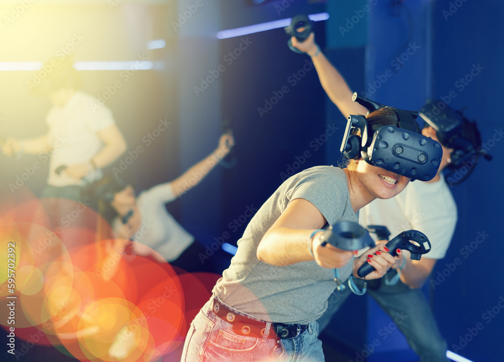 Young woman with handheld controllers in hands clearly excited and ...