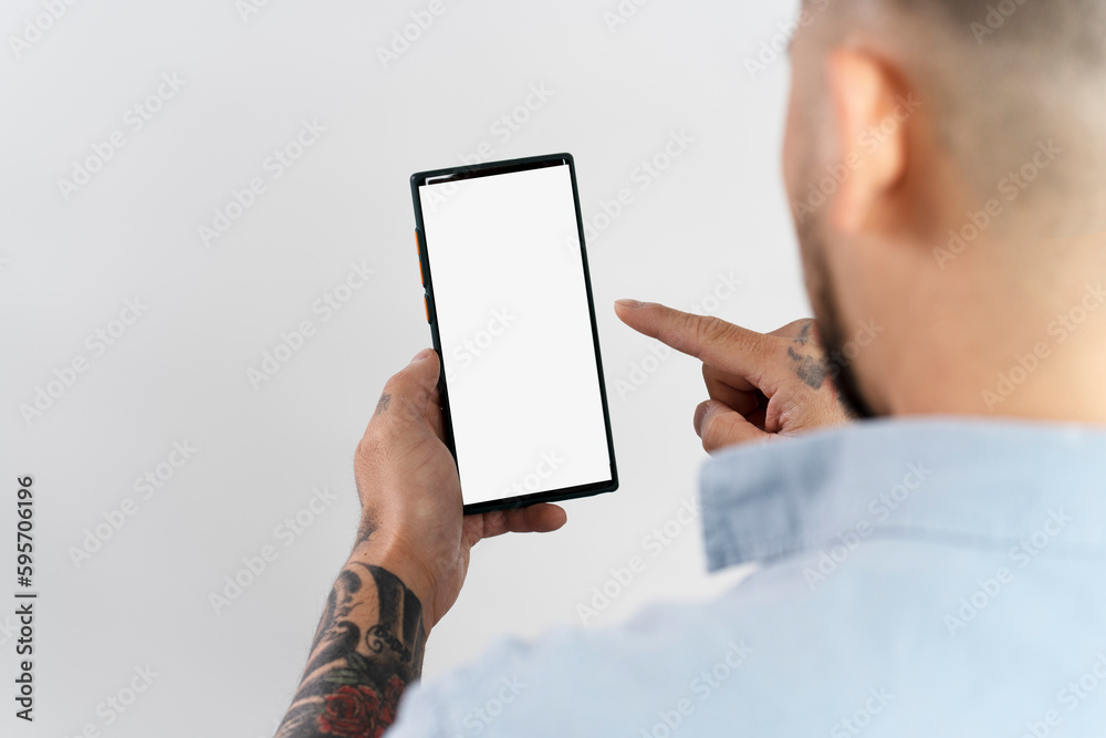Back view of modern man holding smartphone, using mobile app shopping ...