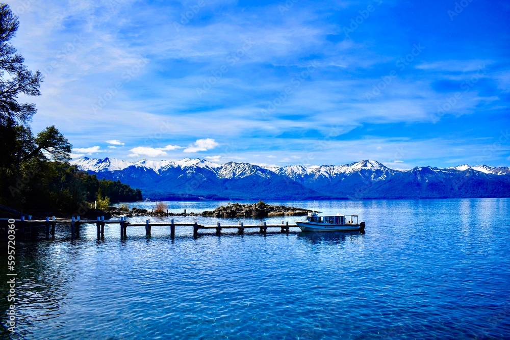muelle y embarcación, con montañas de fondo y lago Stock Photo | Adobe ...