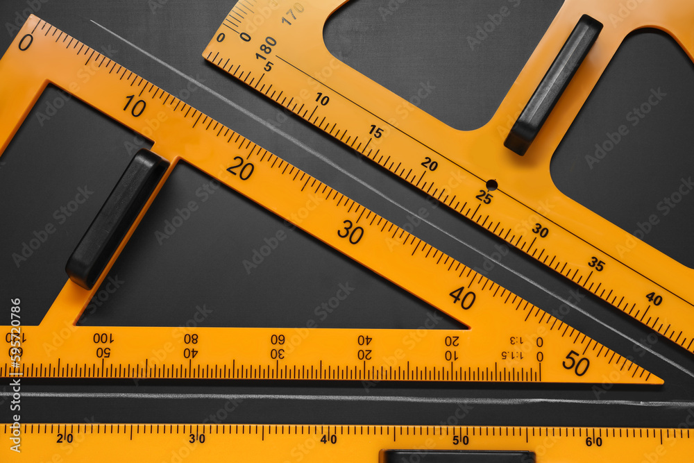 Triangle, protractor, ruler and drawn acute angle on black table, flat ...
