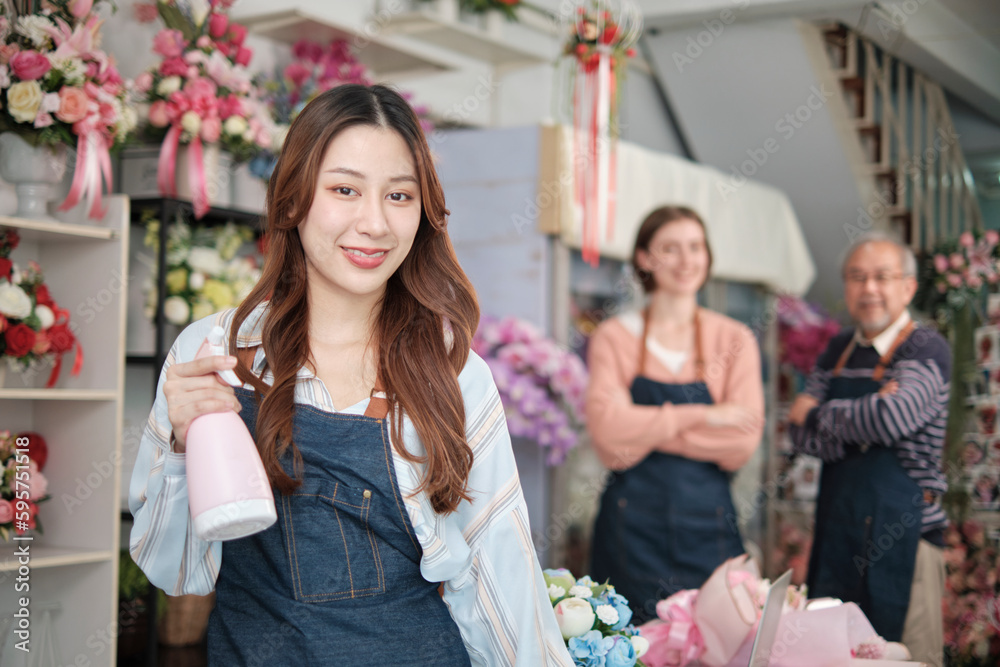 Stockfoto Beautiful young Asian female florist worker with water ...