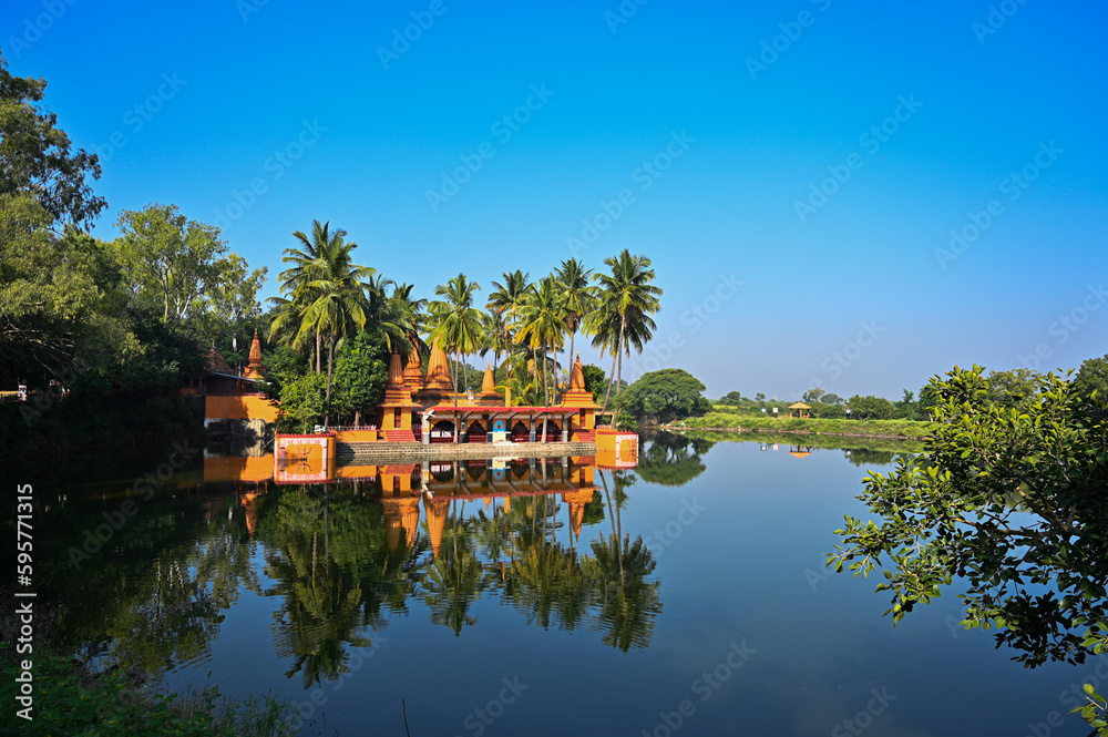 God Temple on the lake. Hindu Temple. Palm trees and lake. Blue Sky ...