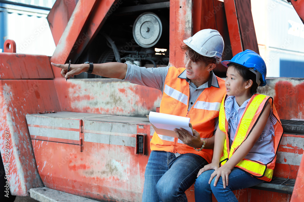 Asian foreman father and his daughter sitting on forklift while using ...