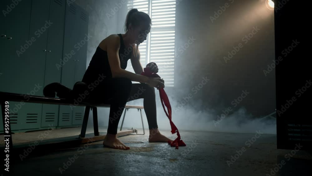 Focused young woman fighter boxer wraps hands wrists with boxing ...
