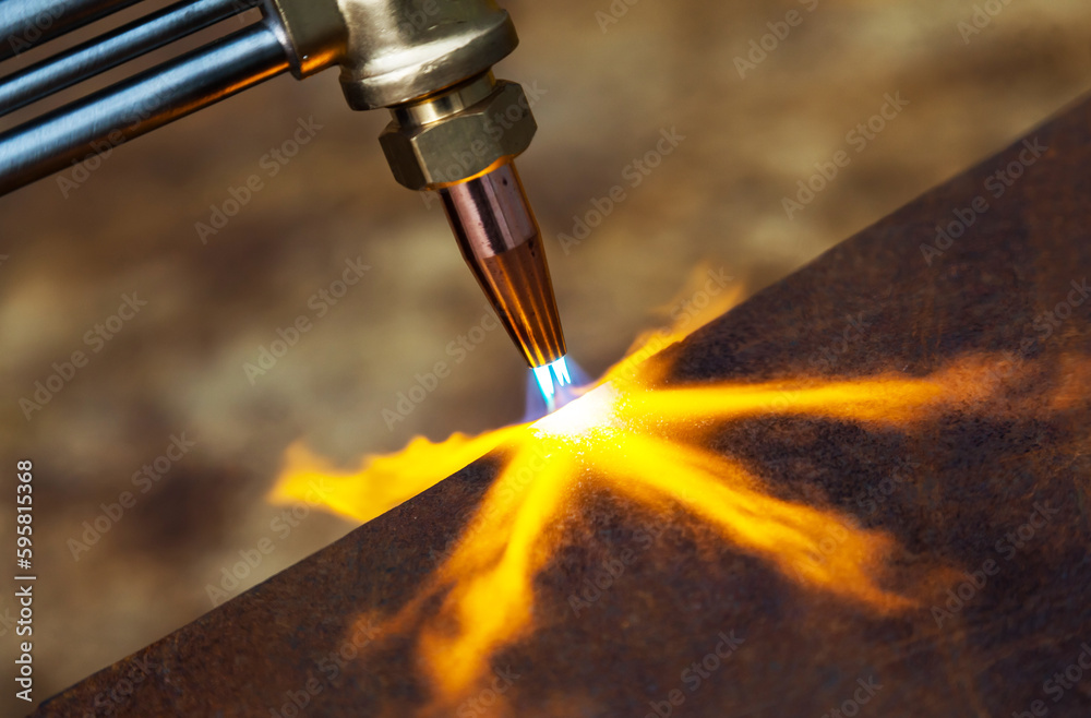 Gas cutting of metal. Gas cutter with copper nozzle with a stream of ...
