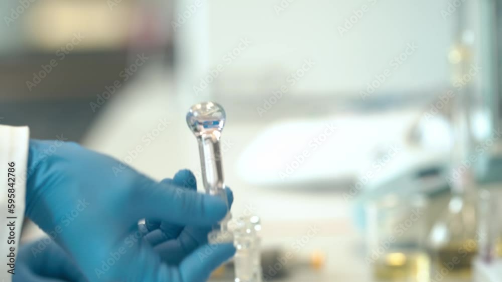mixing a chemical solution in a glass flask during research in a ...