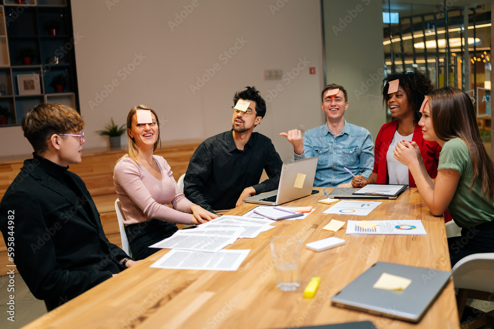 Multiethnic happy excited coworkers playing guessing game with sticky ...