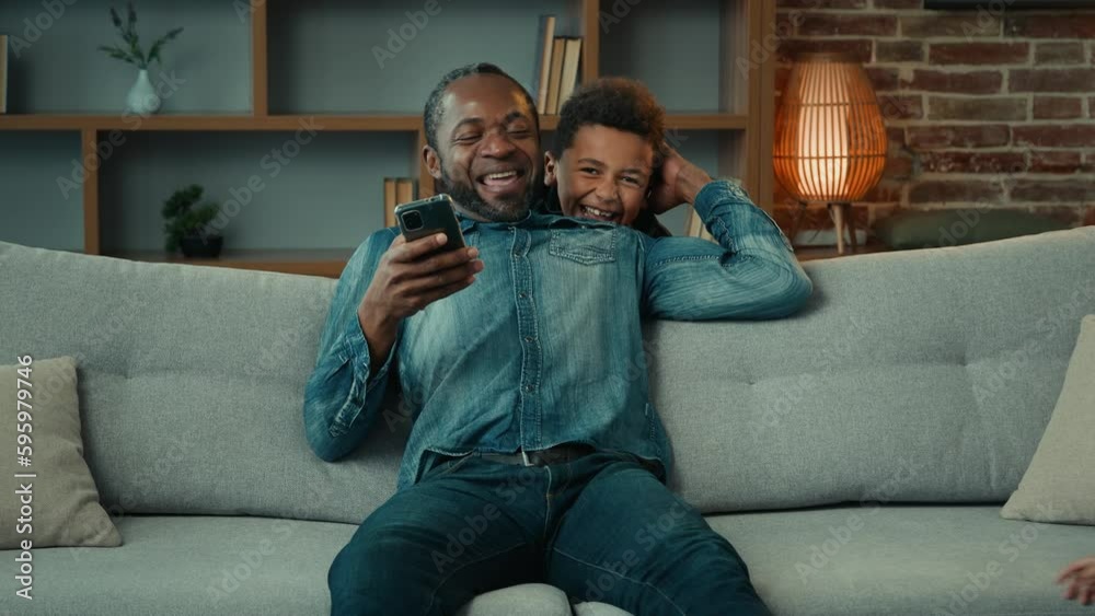 African American man father using mobile phone browsing smartphone at ...