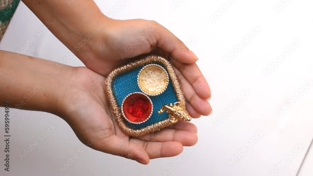 Hand holding beautiful small pooja thali having God Ganesh face, red ...