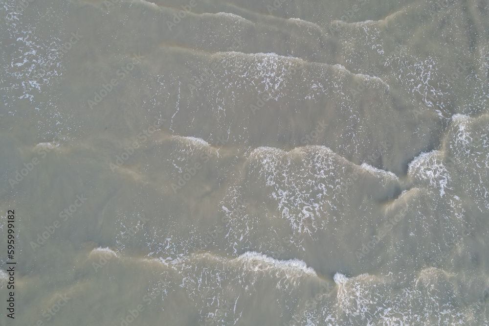 The surface of the sea in shallow water with waves and muddy water ...