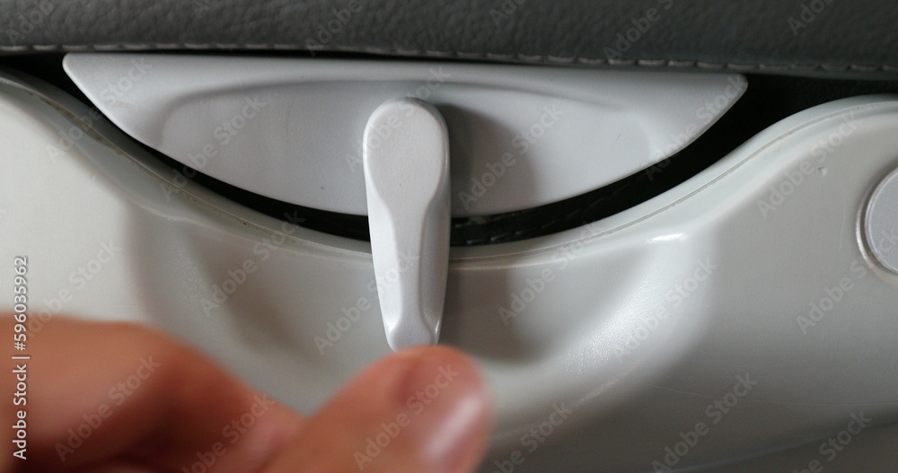 Airplane tray table lock. Closeup of passenger hand opening and closing ... Airplane tray table lock. Closeup of passenger hand opening and closing ...